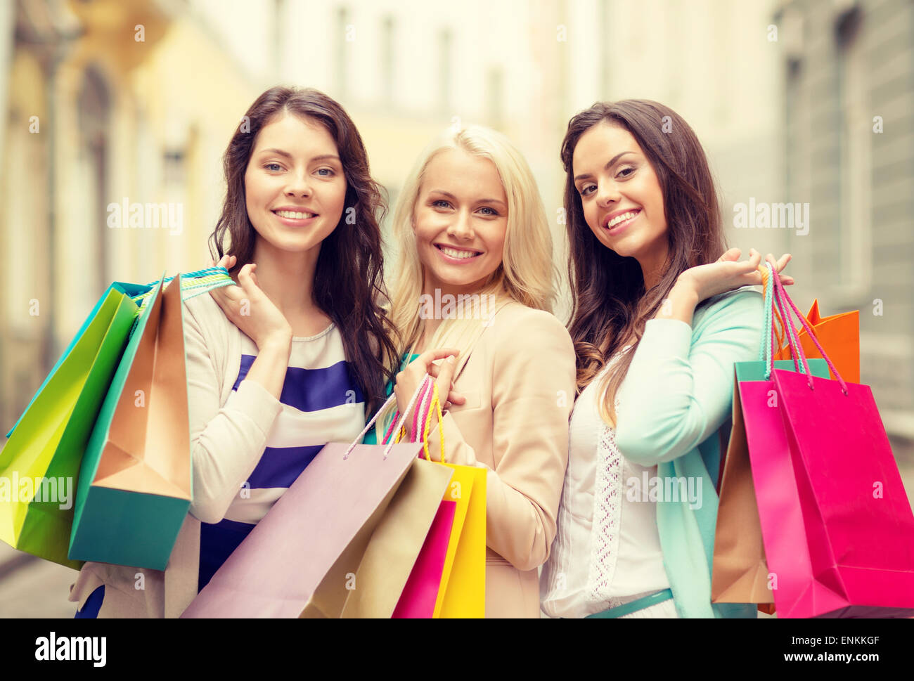 three smiling girls with shopping bags in ctiy Stock Photo - Alamy