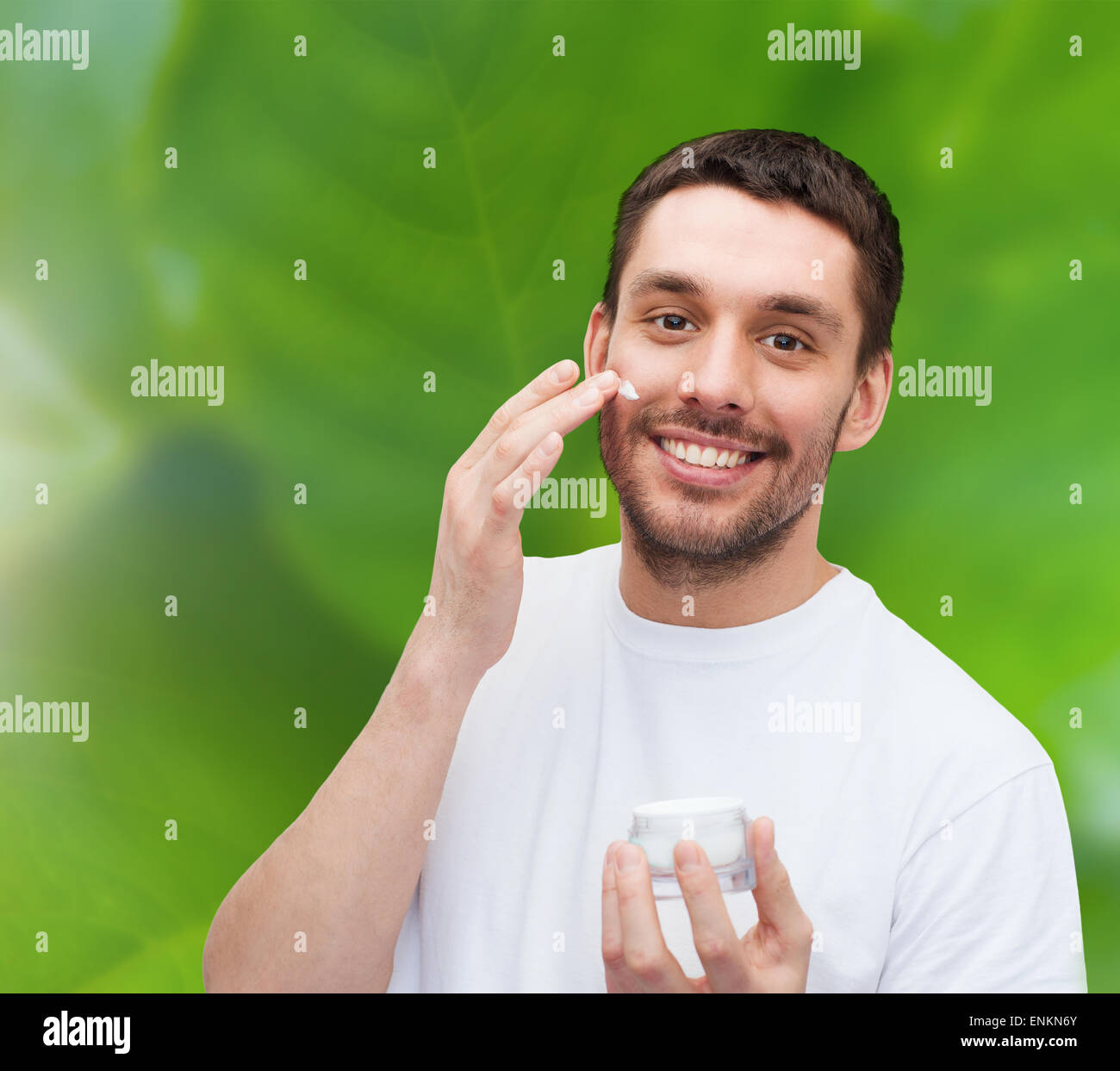 beautiful smiling man applyin cream Stock Photo - Alamy
