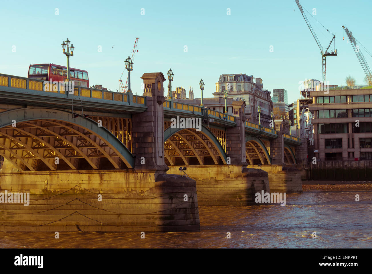 Southwark bridge on a summer's evening with a red London bus going over ...