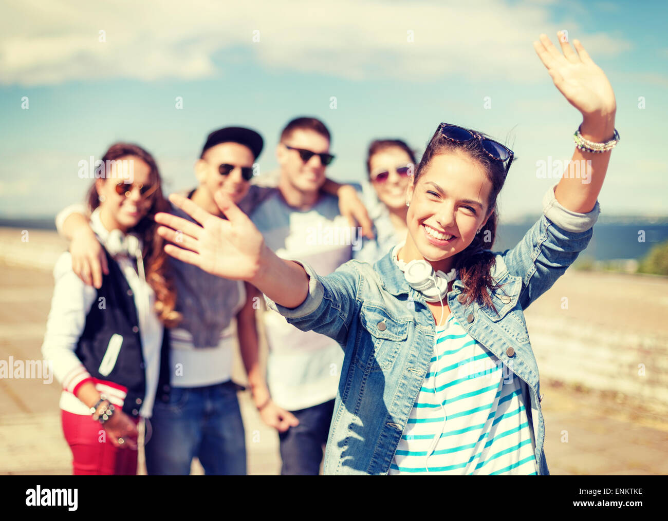 teenage girl with headphones and friends outside Stock Photo - Alamy