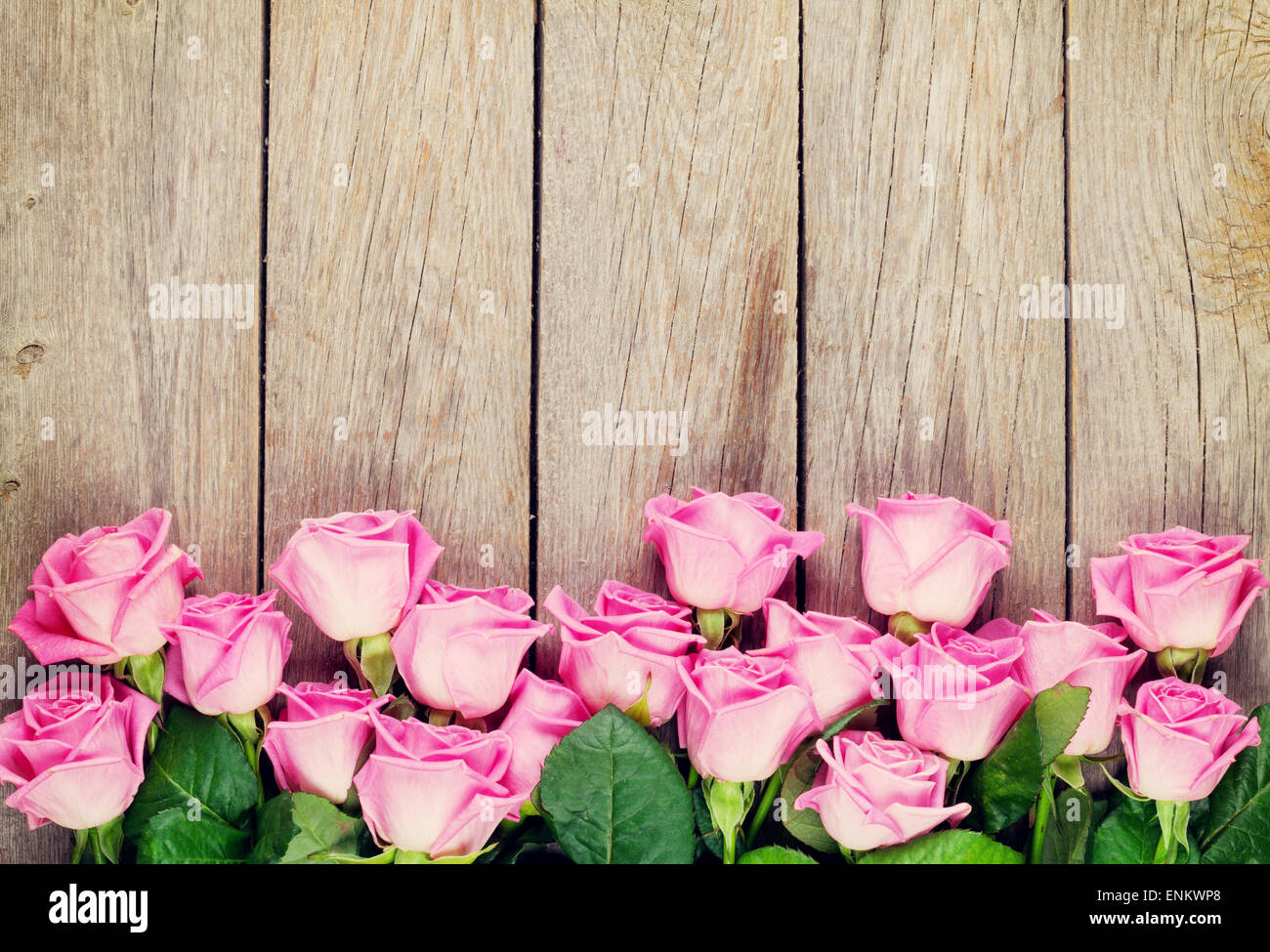 Pink roses bouquet over wooden table. Top view with copy space. Toned ...