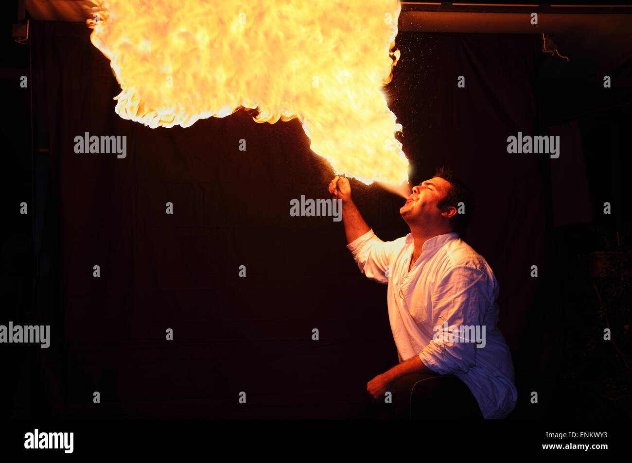 fire-eater with flame over dark background Stock Photo - Alamy