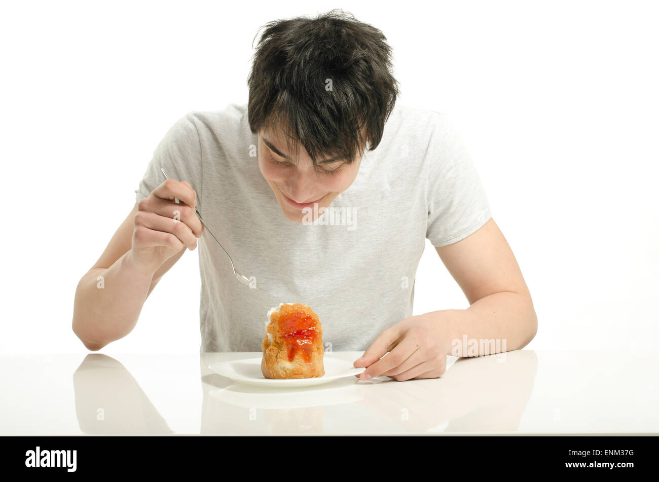 Young man eating a cream cake, man tasting sweets, tasting a cookie ...