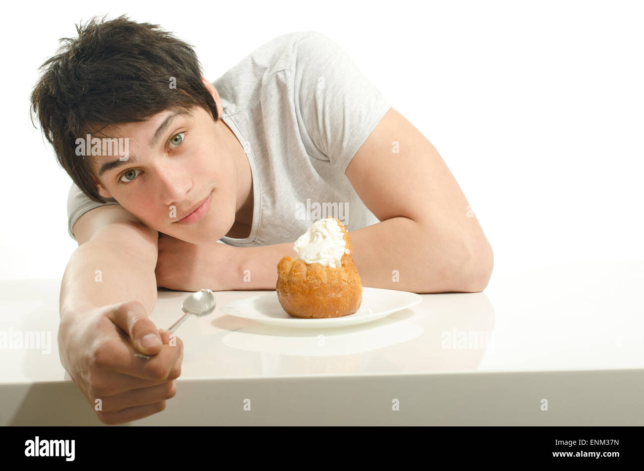 Young man eating a cream cake, man tasting sweets, tasting a cookie ...