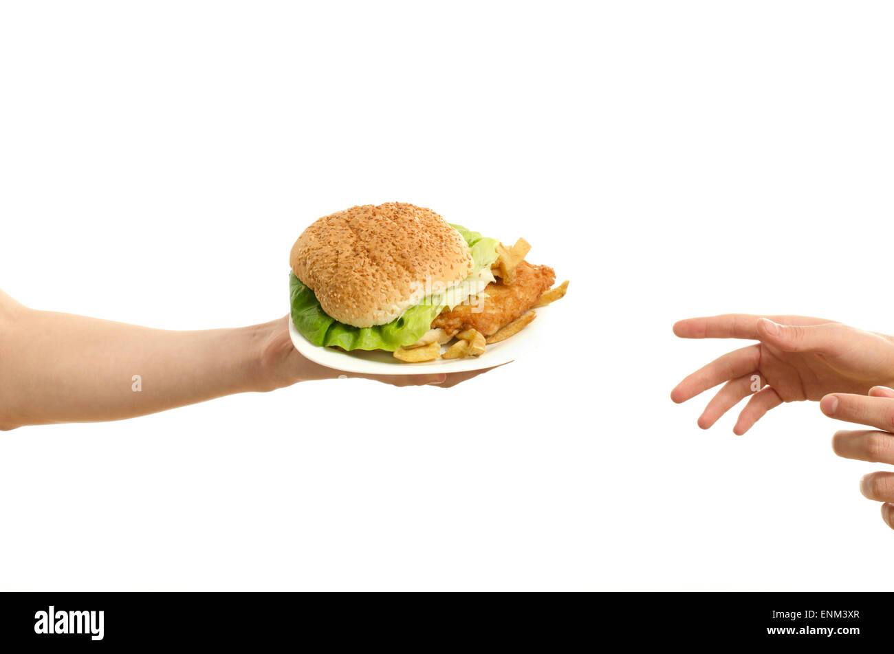 Hands offering a big hamburger and hungry hands ready to receive ...