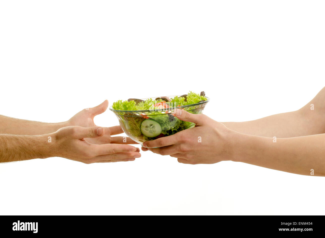 Hand offering a bowl of organic salad and other hands receiving ...