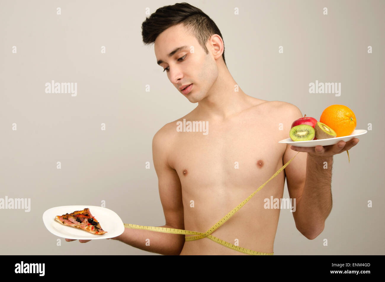 Man choosing between fruits, organic healthy food against pizza, fast ...