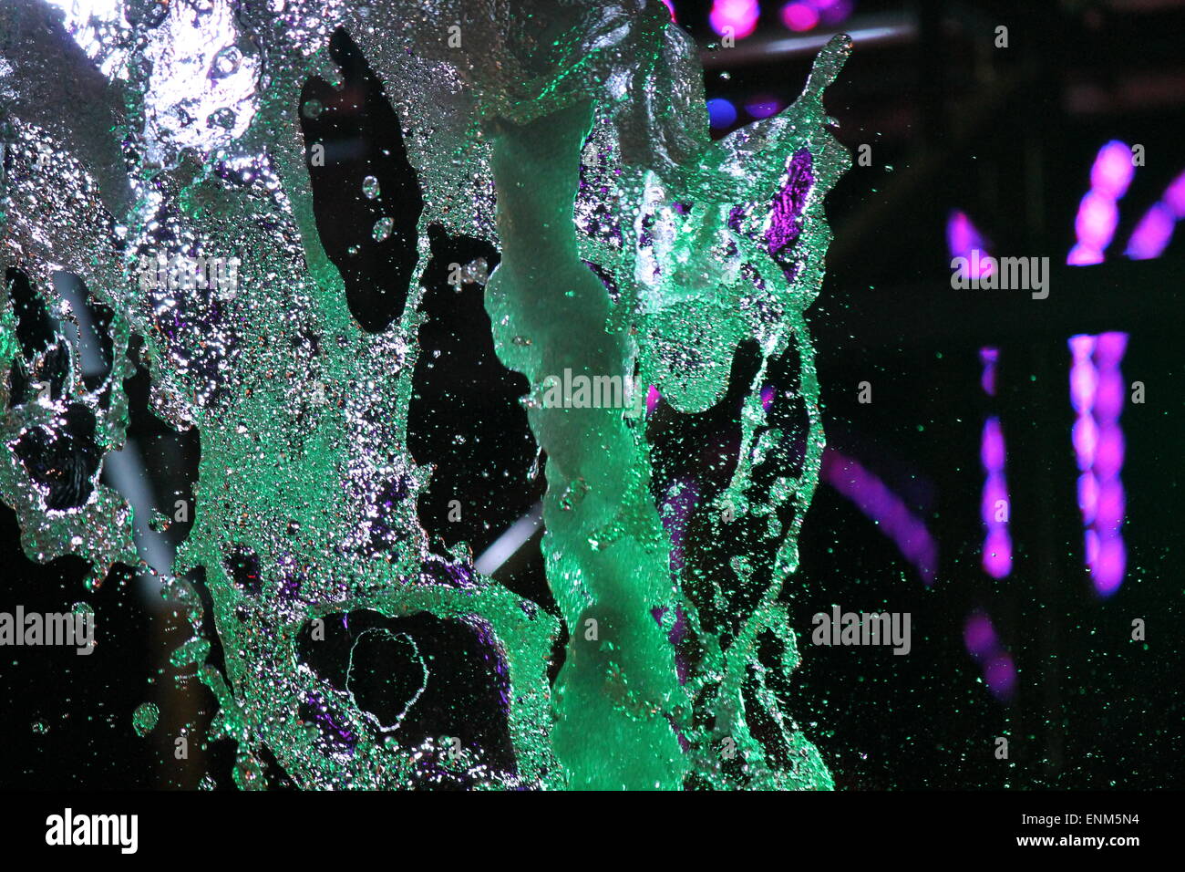 Fountain water splashing by lights at night Stock Photo - Alamy