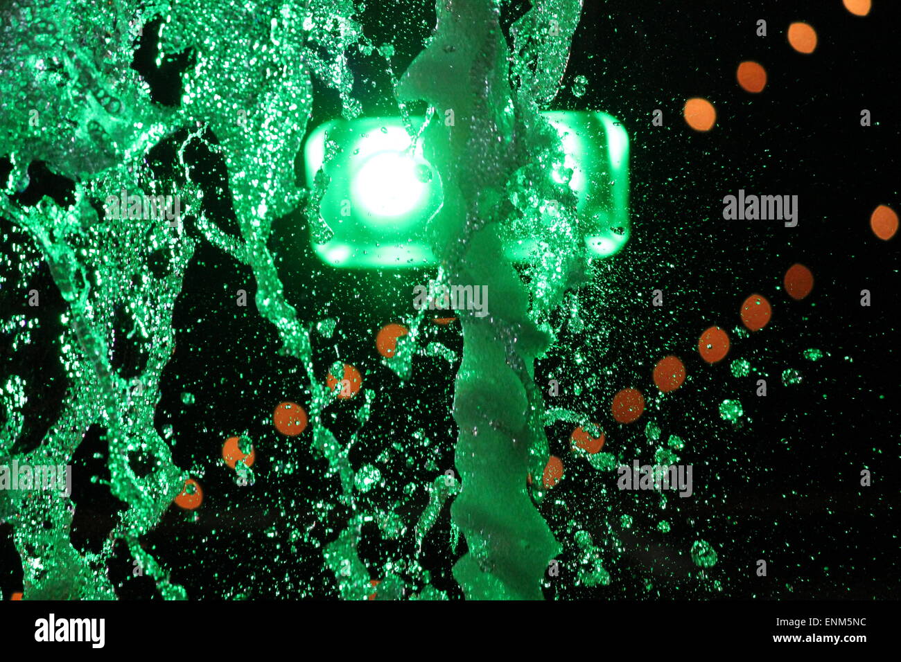 Fountain water splashing by lights at night Stock Photo - Alamy