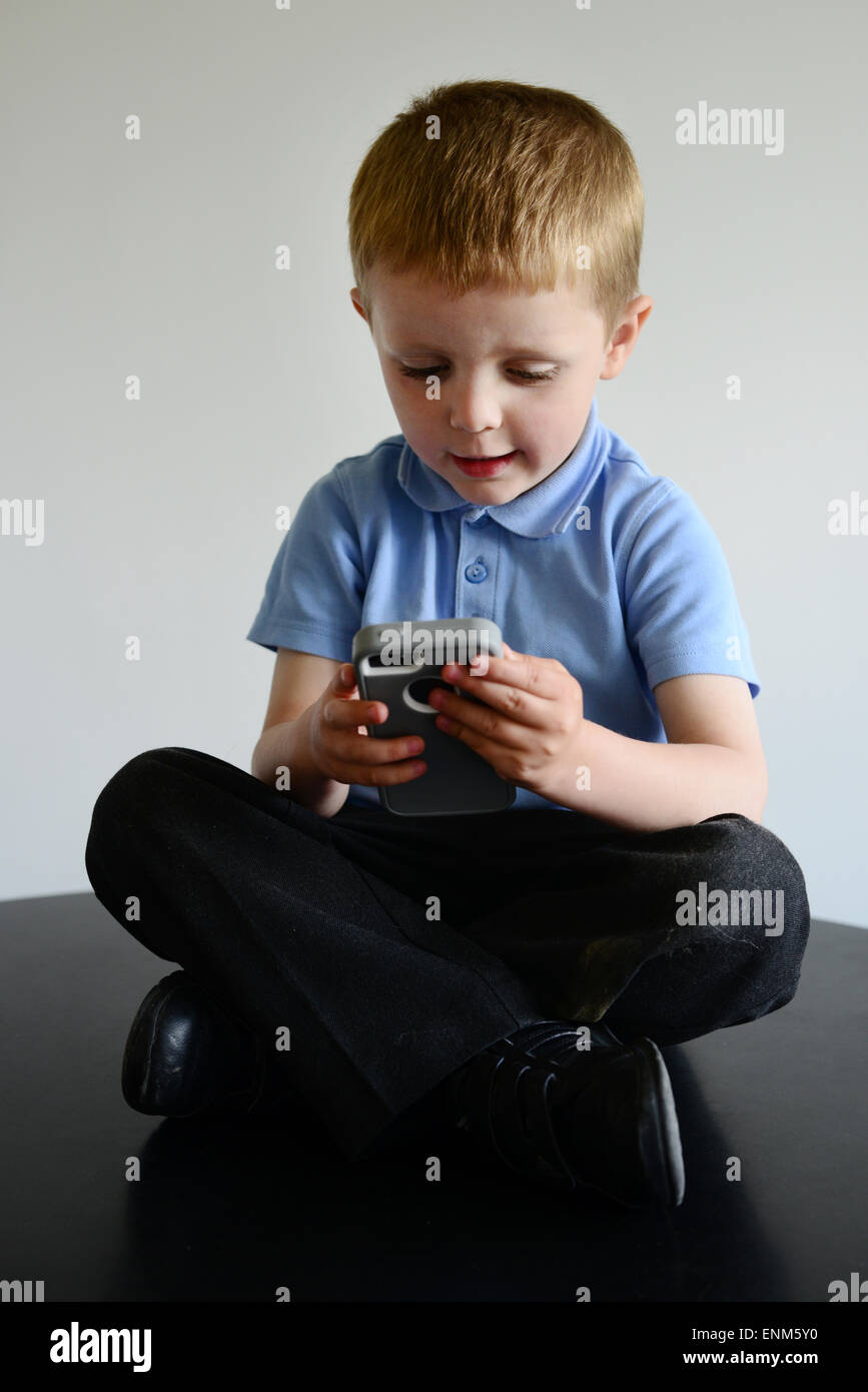 A little boy playing with a Apple iPhone. Picture: Scott Bairstow/Alamy ...