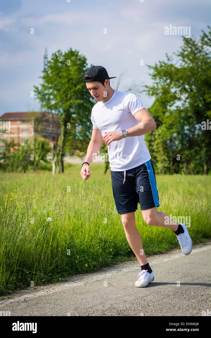 Young man getting injured while running spraining an ankle Stock Photo ...