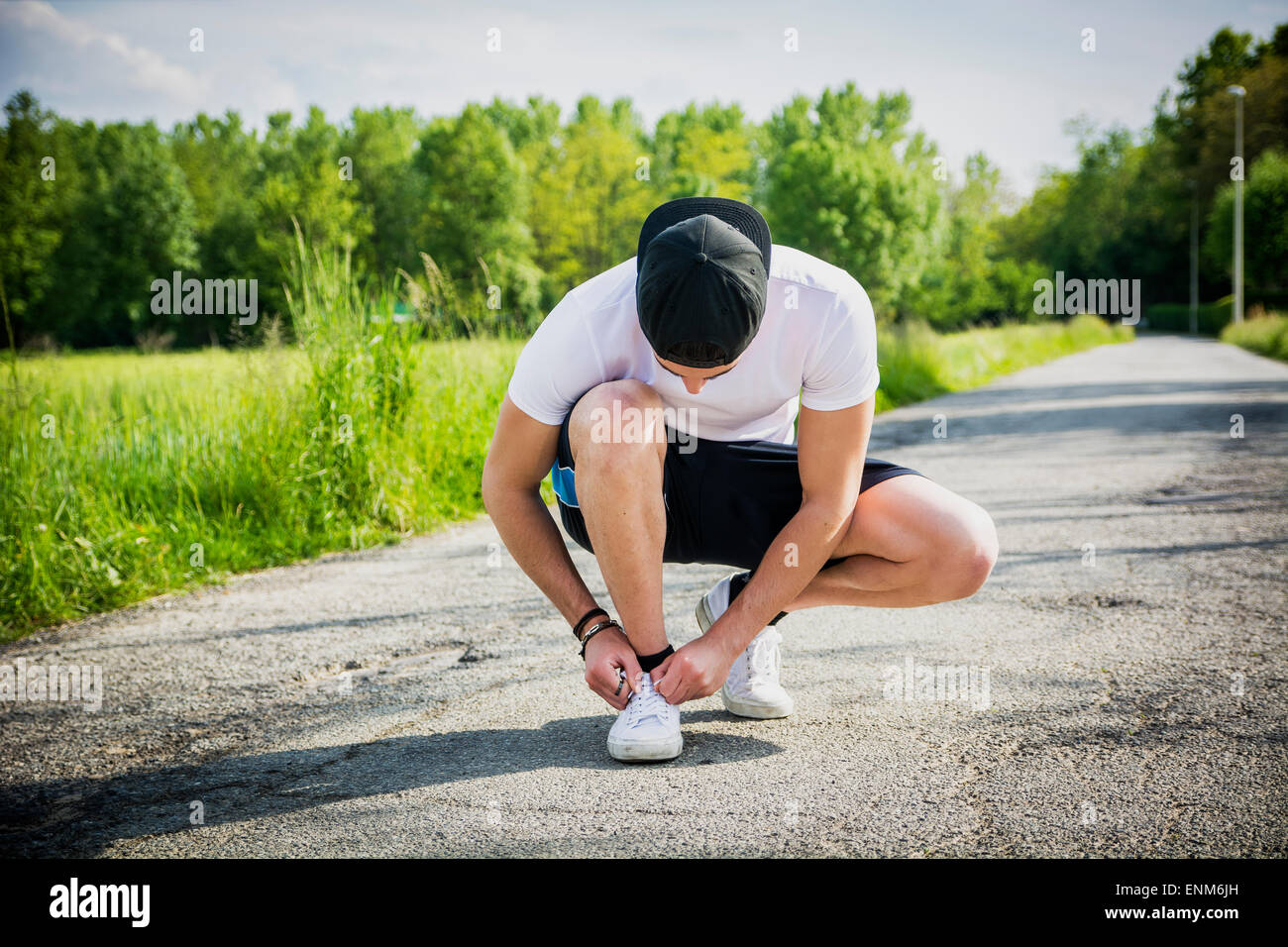 Handsome young man tying sports shoes before going running Stock Photo ...