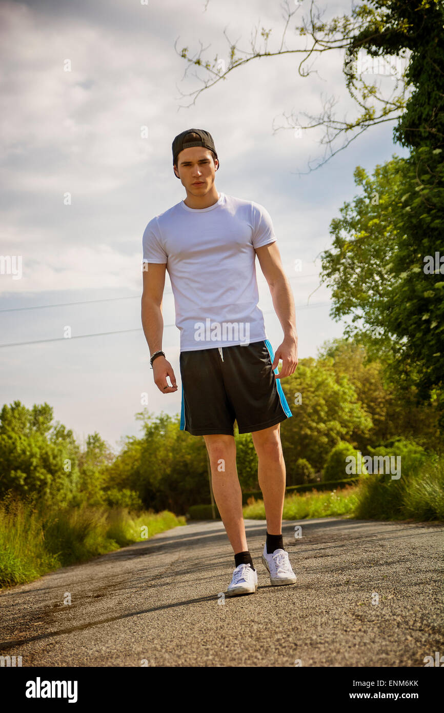 Handsome young man walking and trekking on road Stock Photo - Alamy