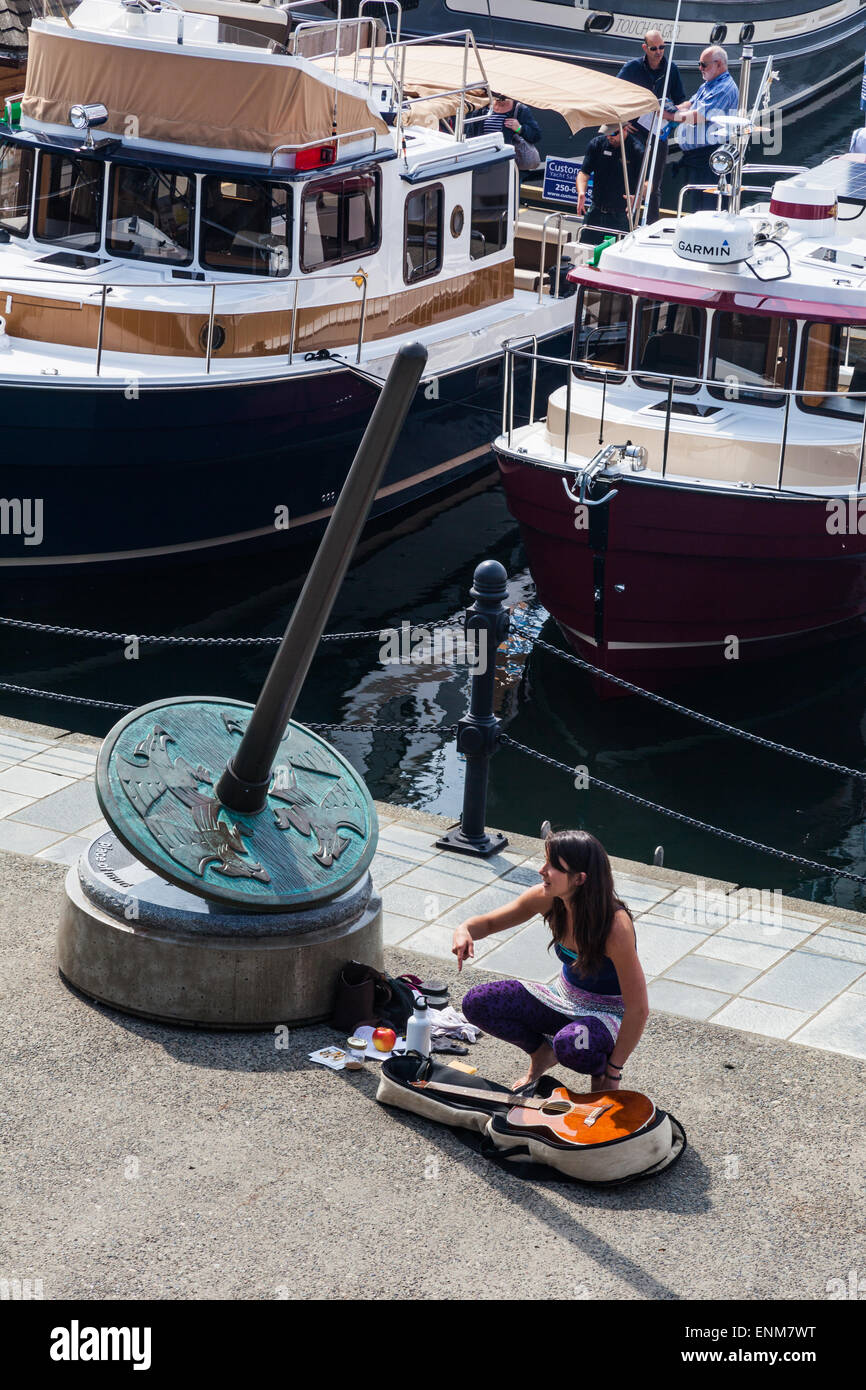 Female street entertainer getting ready to play at the Inner Harbour in ...