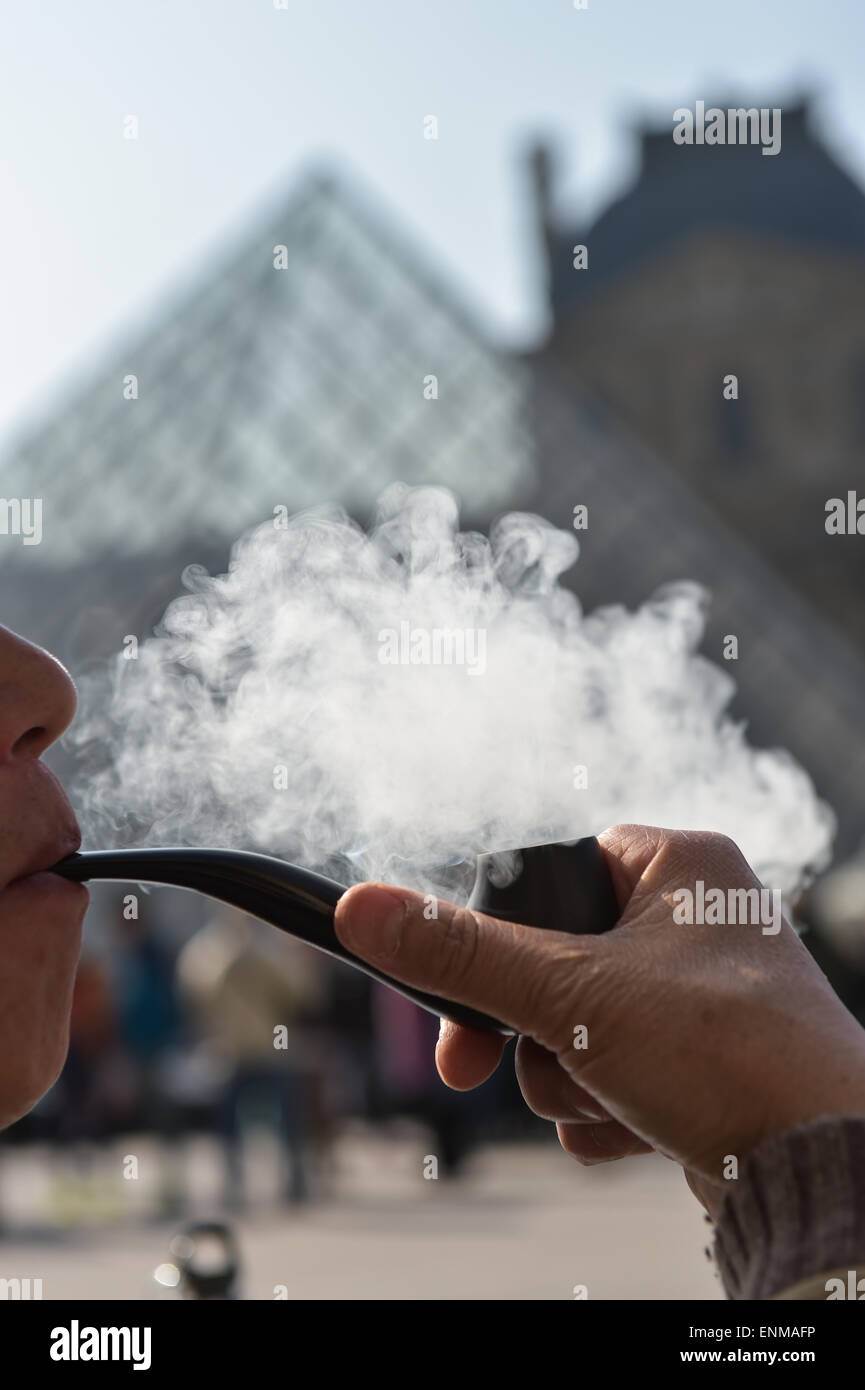Mature man smoking pipe outdoors, profile,France, Paris, Louvre Art ...
