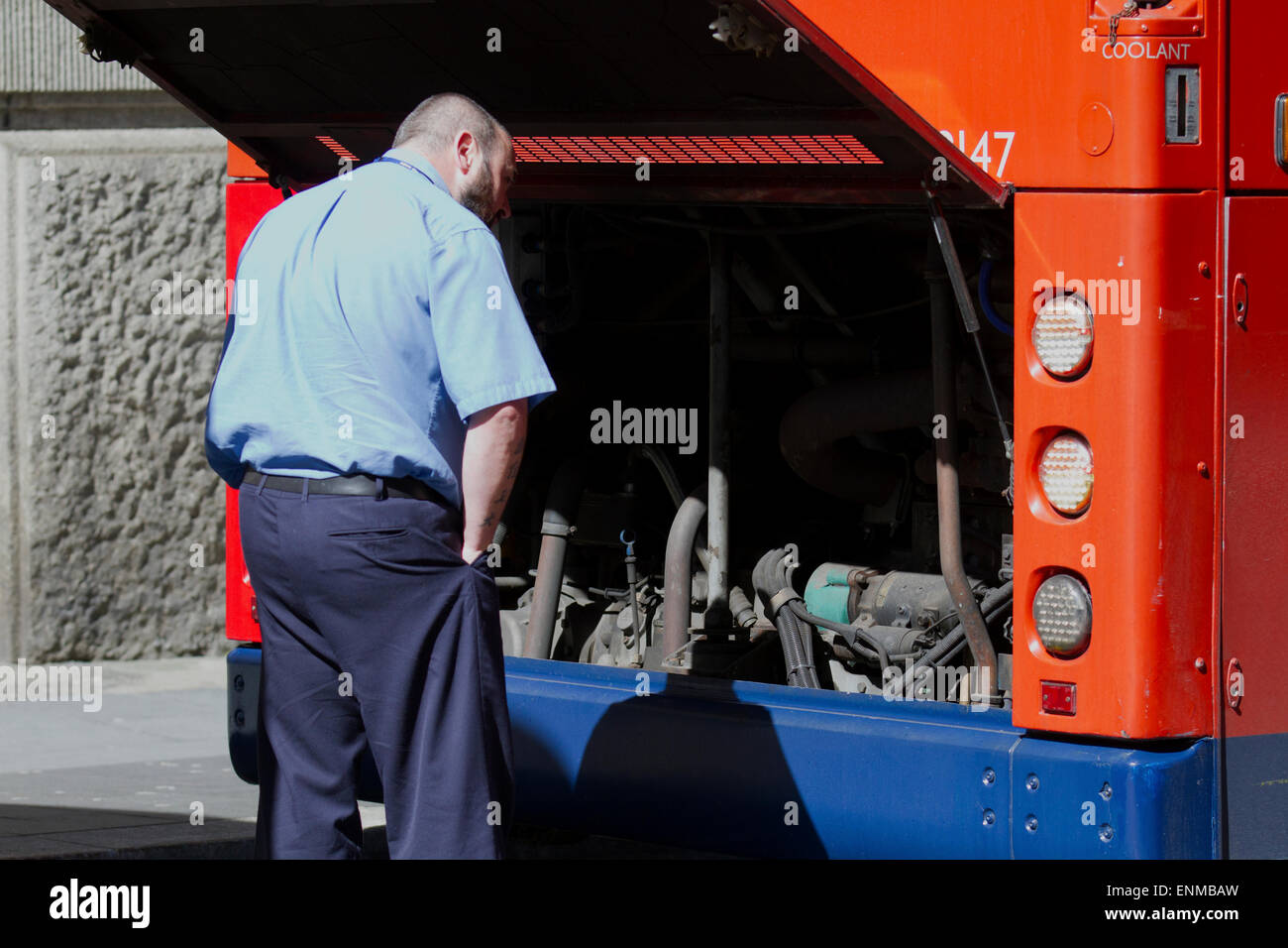 Bus driver looking at engine of broken down bus on Castle Street ...