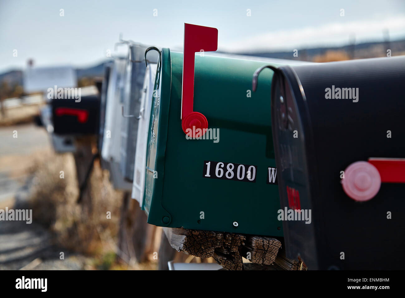 Green mailbox in a row with black, silver and white mailboxes Stock ...