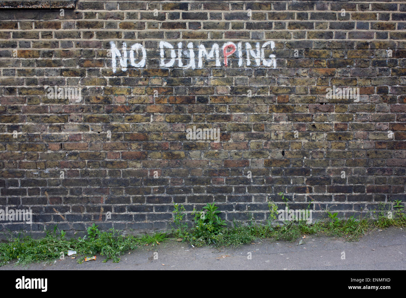 No Dumping writing painted on an urban brick wall in the south London ...