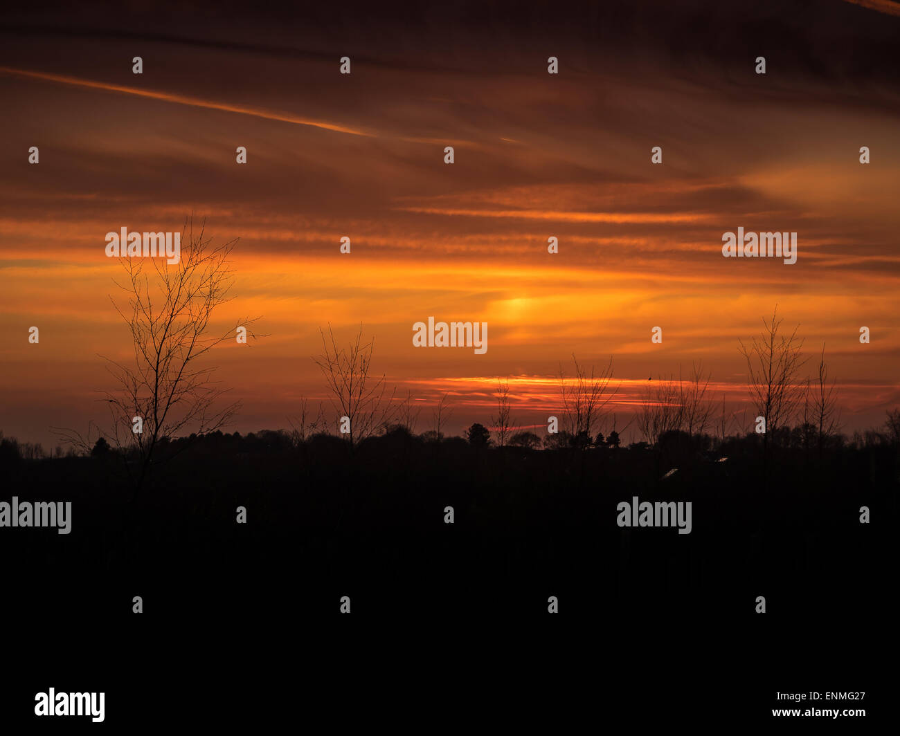 Deep glow sunset over tree lined countryside Stock Photo - Alamy