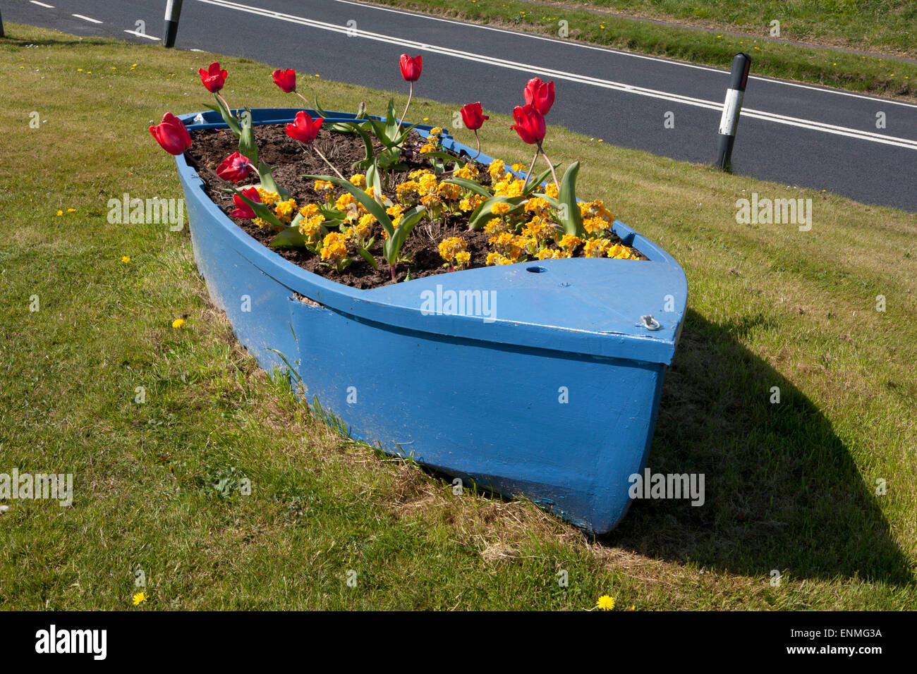 A display of flowers in an old sailing boat beside a road in Looe ...