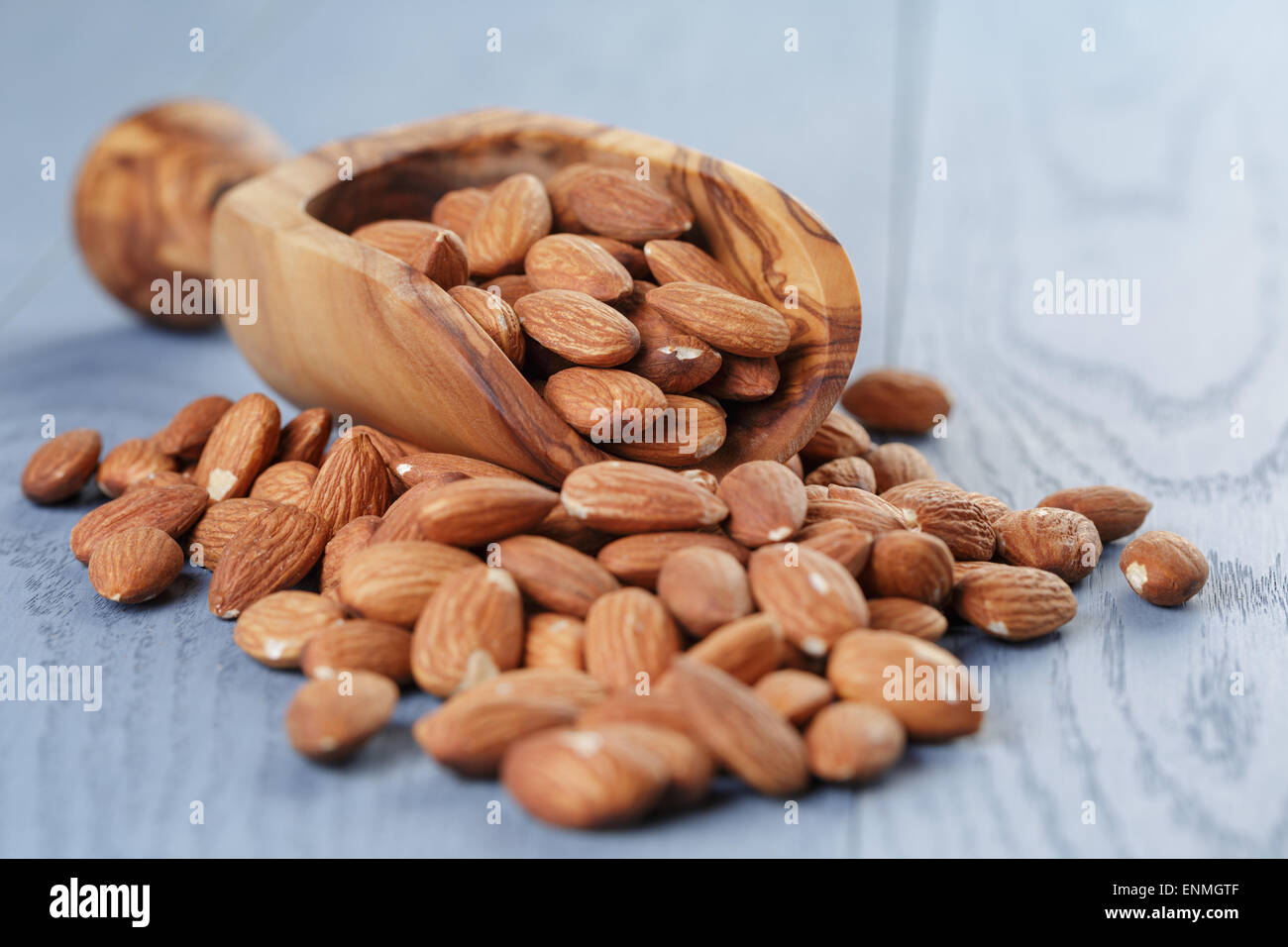 roasted almonds in measuring scoop on blue wooden table Stock Photo - Alamy