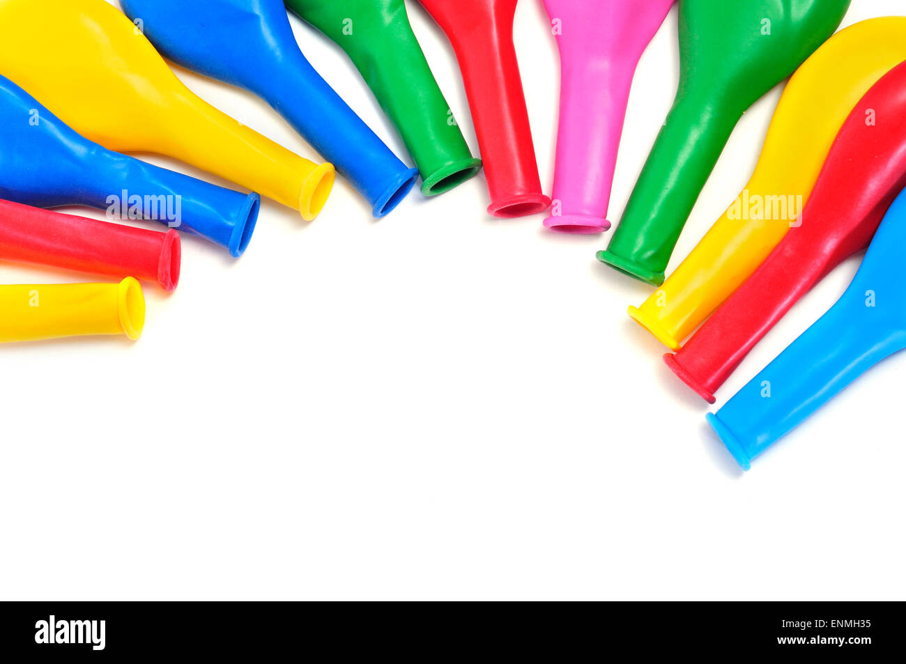 a pile of uninflated balloons of different colors on a white background ...