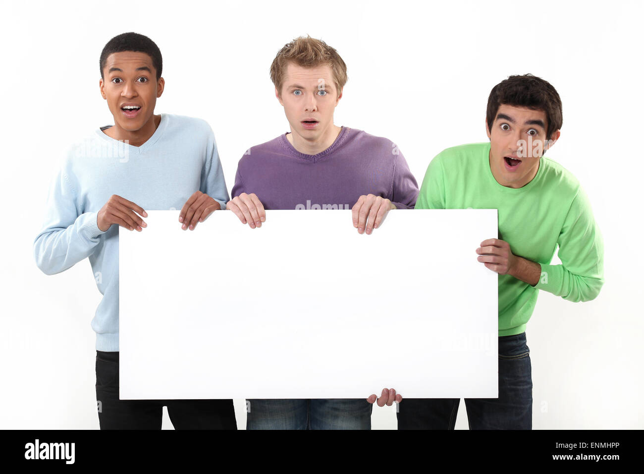 Three surprised men holding poster Stock Photo - Alamy