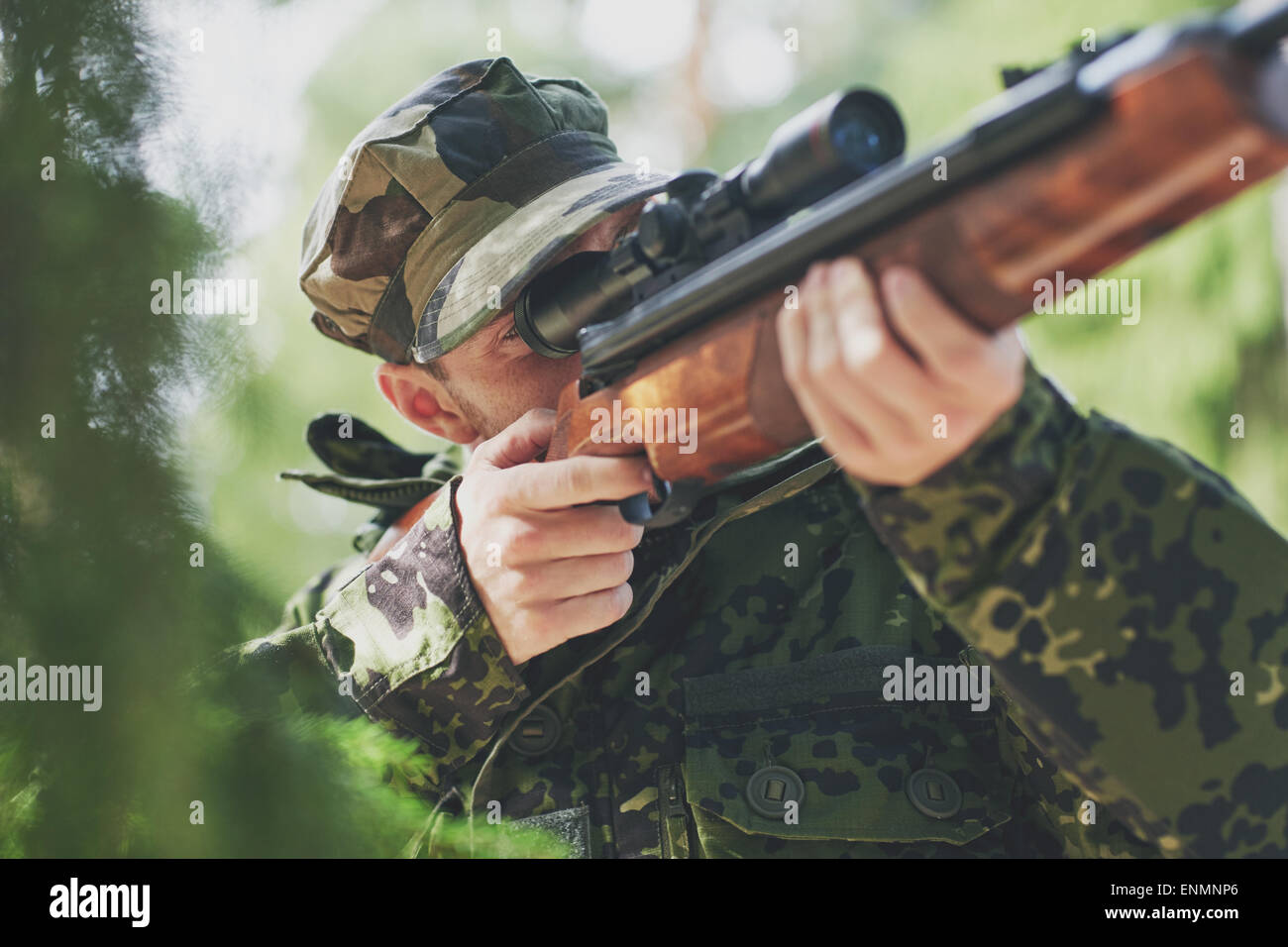soldier or hunter shooting with gun in forest Stock Photo - Alamy