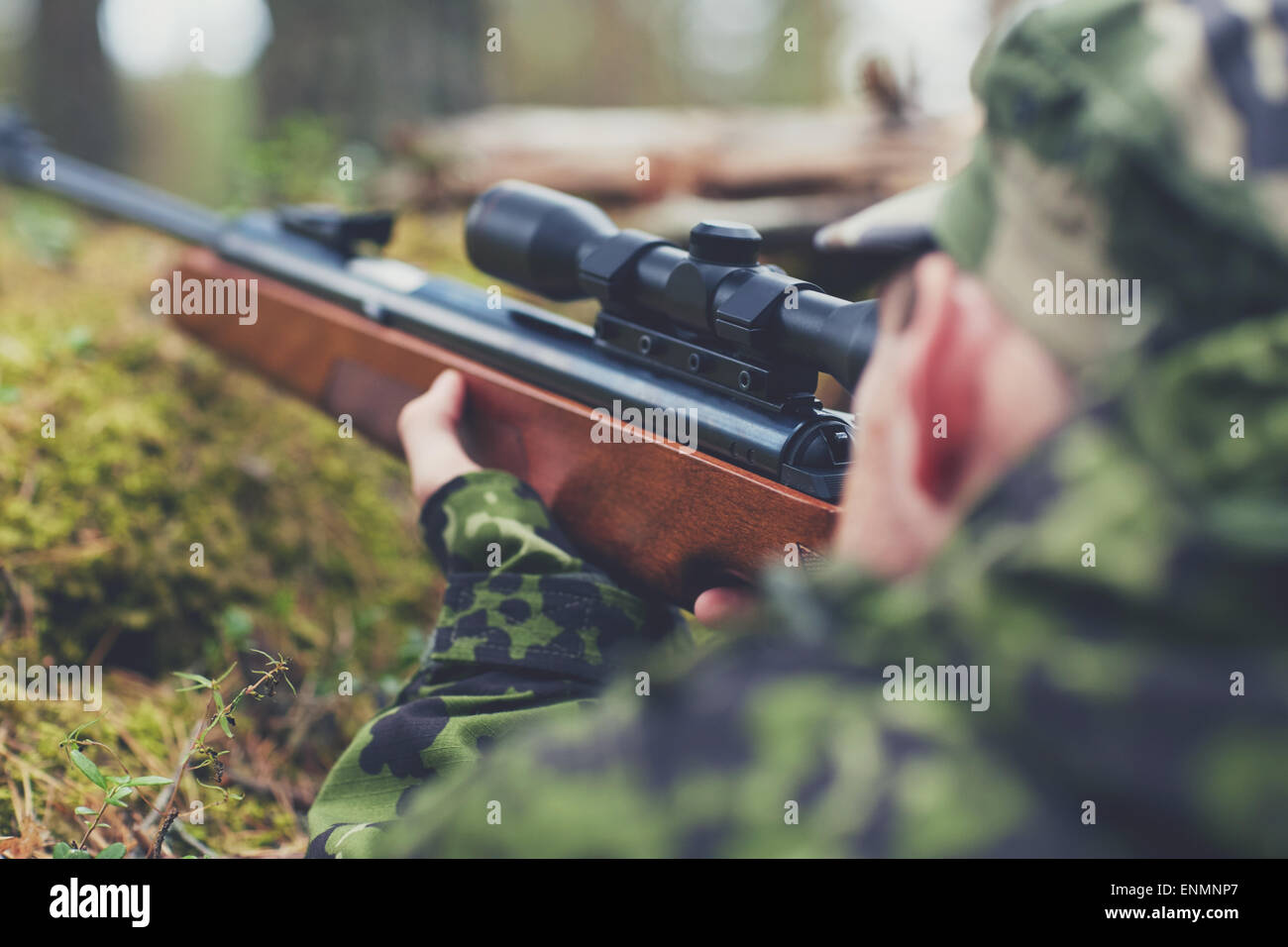 soldier or hunter shooting with gun in forest Stock Photo - Alamy