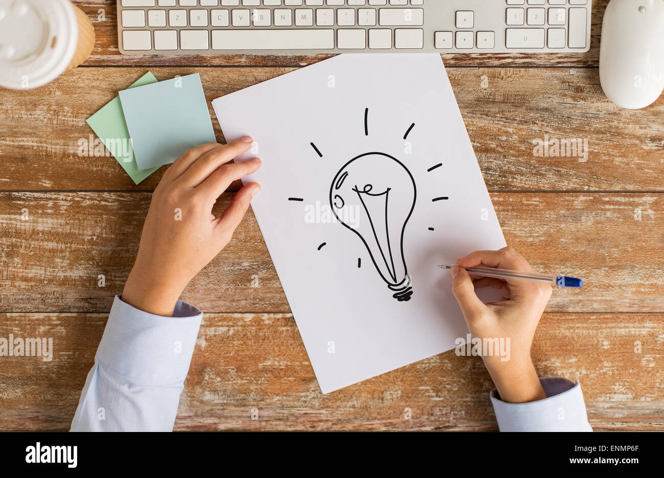 close up of hands drawing lighting bulb on paper Stock Photo - Alamy