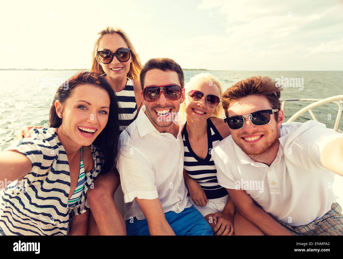 smiling friends sitting on yacht deck Stock Photo - Alamy