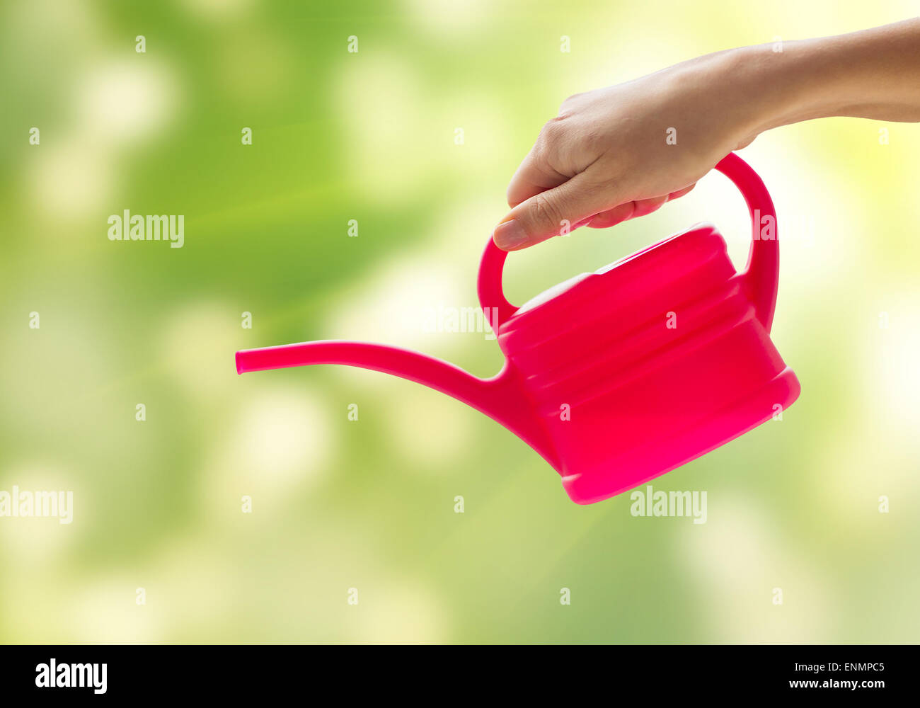 Hand holding green watering can hi-res stock photography and images - Alamy