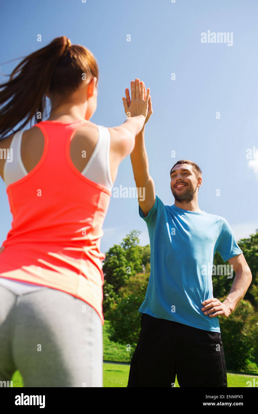 two smiling people making high five outdoors Stock Photo - Alamy