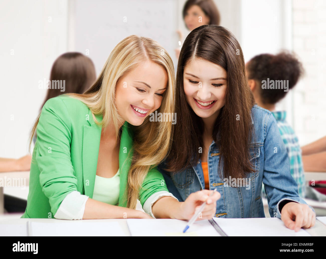 student girls pointing at notebook at school Stock Photo - Alamy