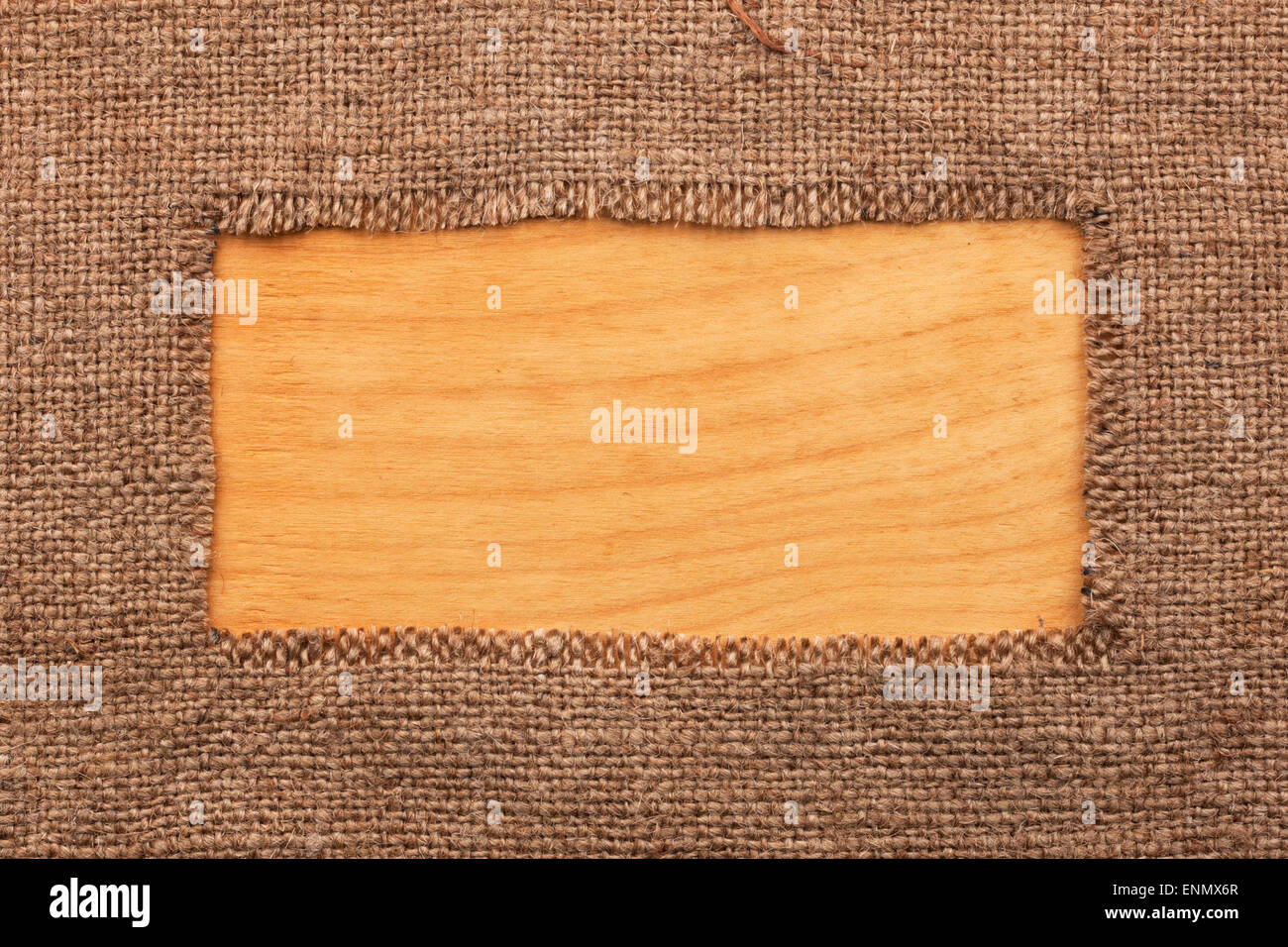 Frame made of burlap lying on a wooden surface, with space for your ...