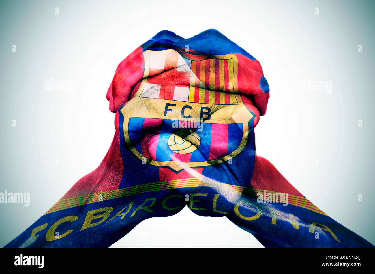 the clasped hands of a young man patterned with the flag of the Futbol ...
