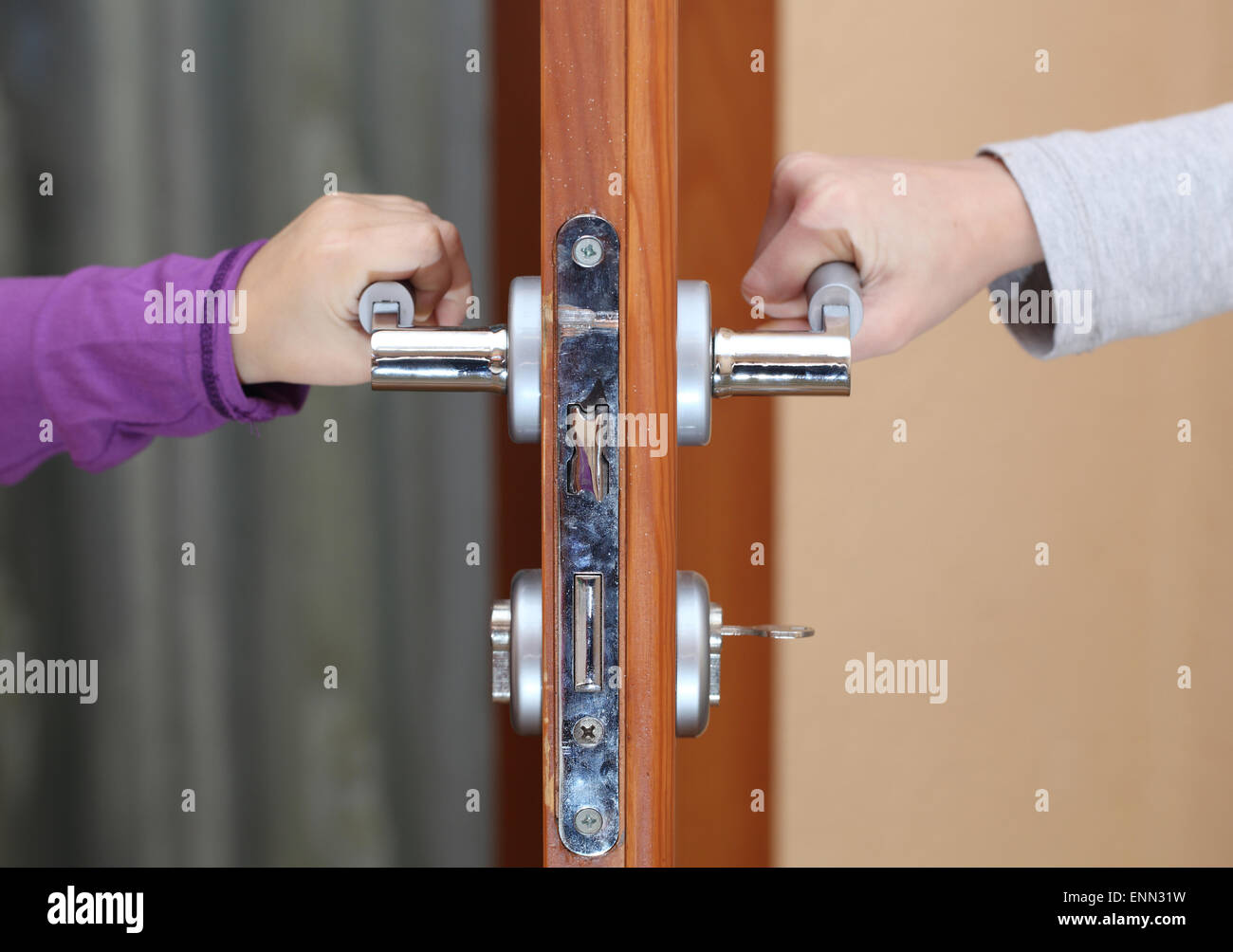 children hold hands on the door handle Stock Photo - Alamy