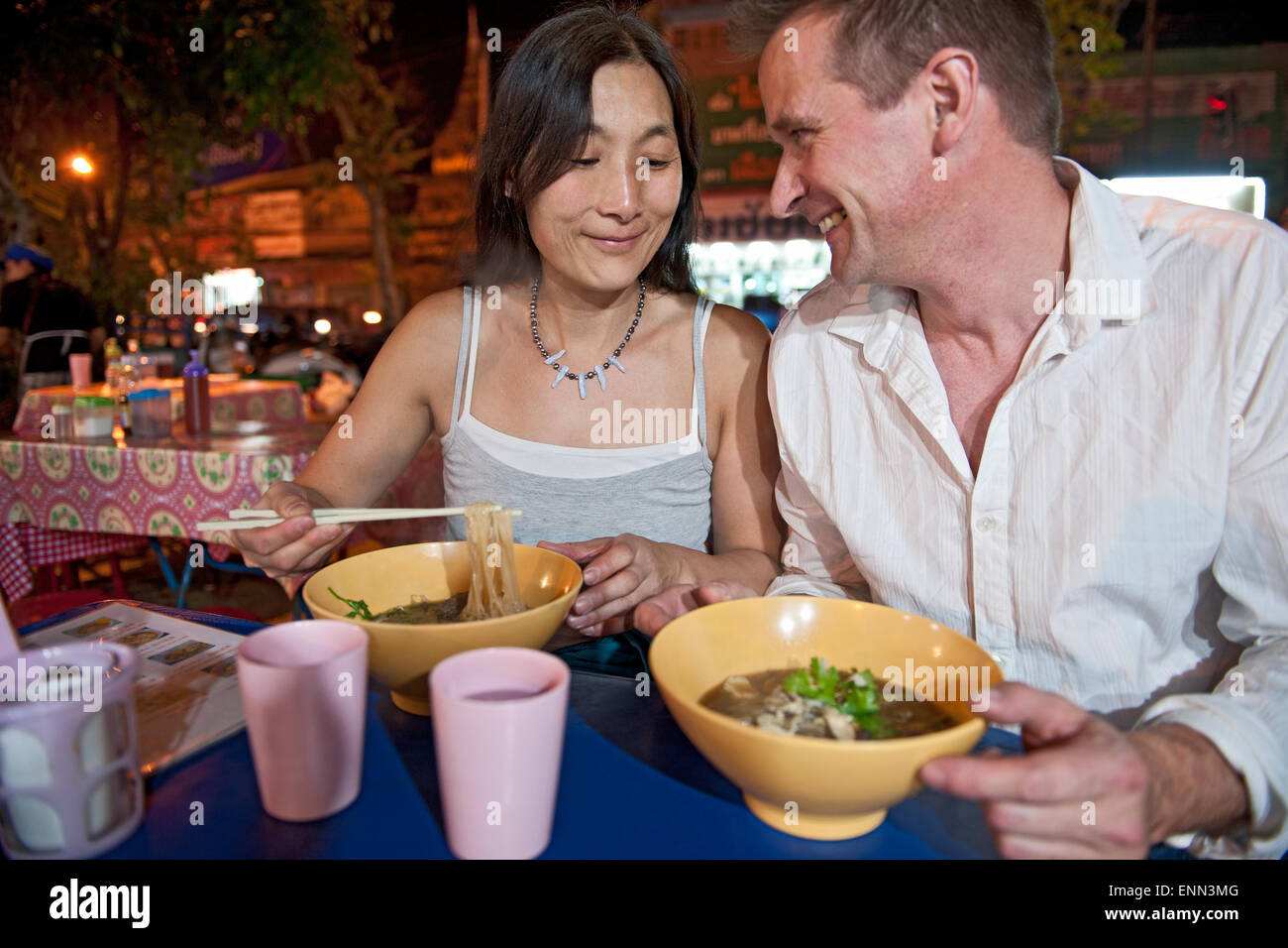 couple eating noodle soup at Thai open air market Stock Photo - Alamy
