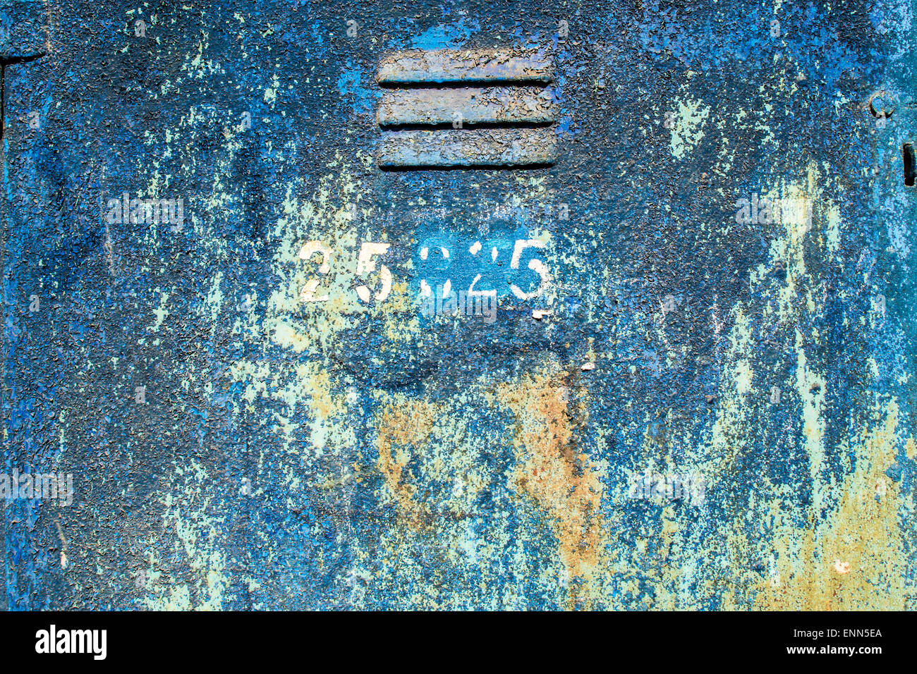 Flaking aged blue paint flecks on metal with rust and an exposed vent ...