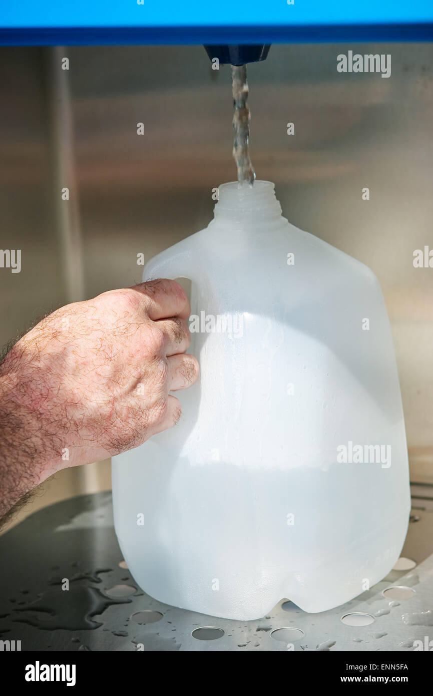 Closeup of a man's hand filling a gallon jug from a water machine Stock ...