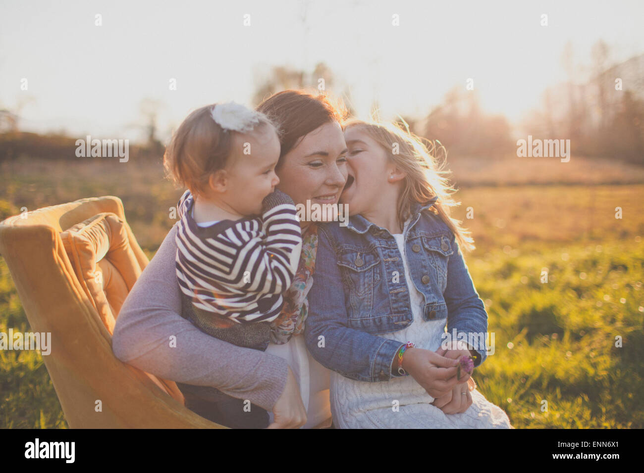 A mother holds her two daughters Stock Photo - Alamy