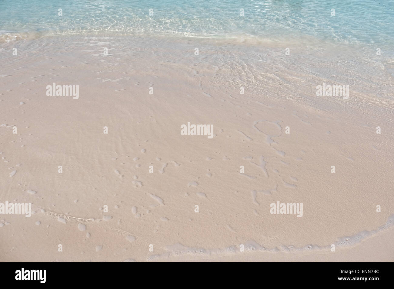 A wave gently washing over a sandy beach in the Caribbean Stock Photo ...