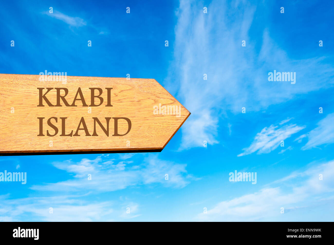 Wooden arrow sign pointing destination KRABI ISLAND, THAILAND against ...