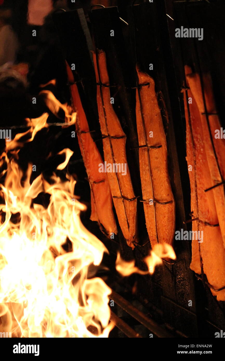 Salmon being smoked by an open wood fire Stock Photo - Alamy