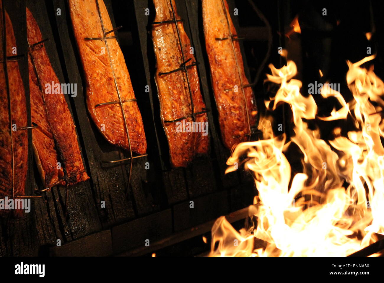 Salmon being smoked by an open wood fire Stock Photo - Alamy