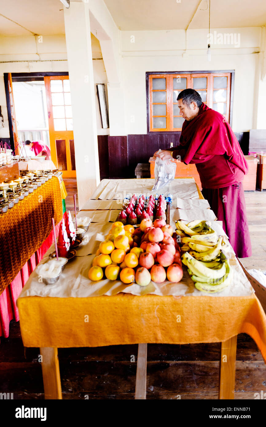 A monk preparing the offerings at a shrine inside the Dunggon Samten ...