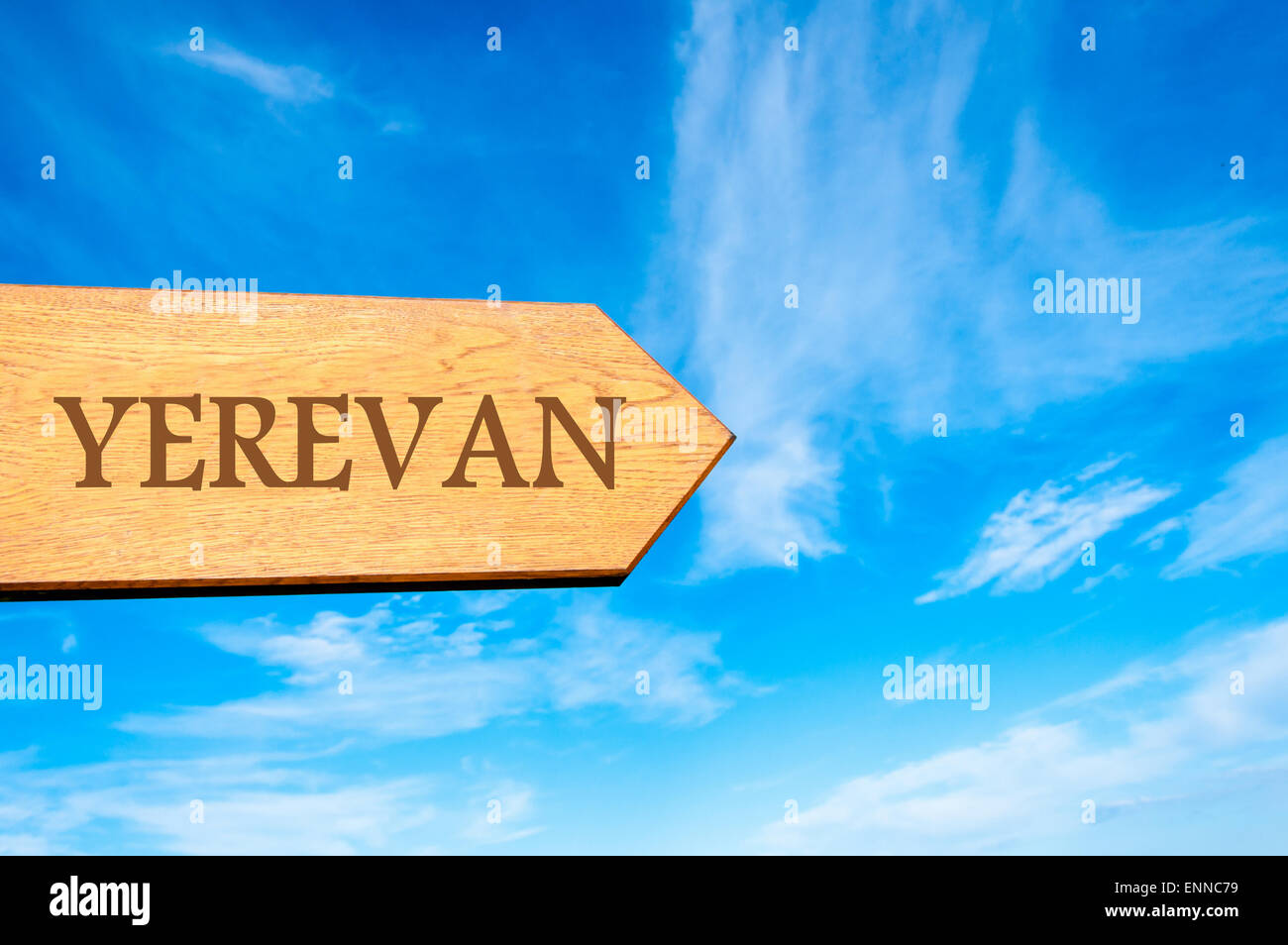Wooden arrow sign pointing destination YEREVAN, ARMENIA against clear ...