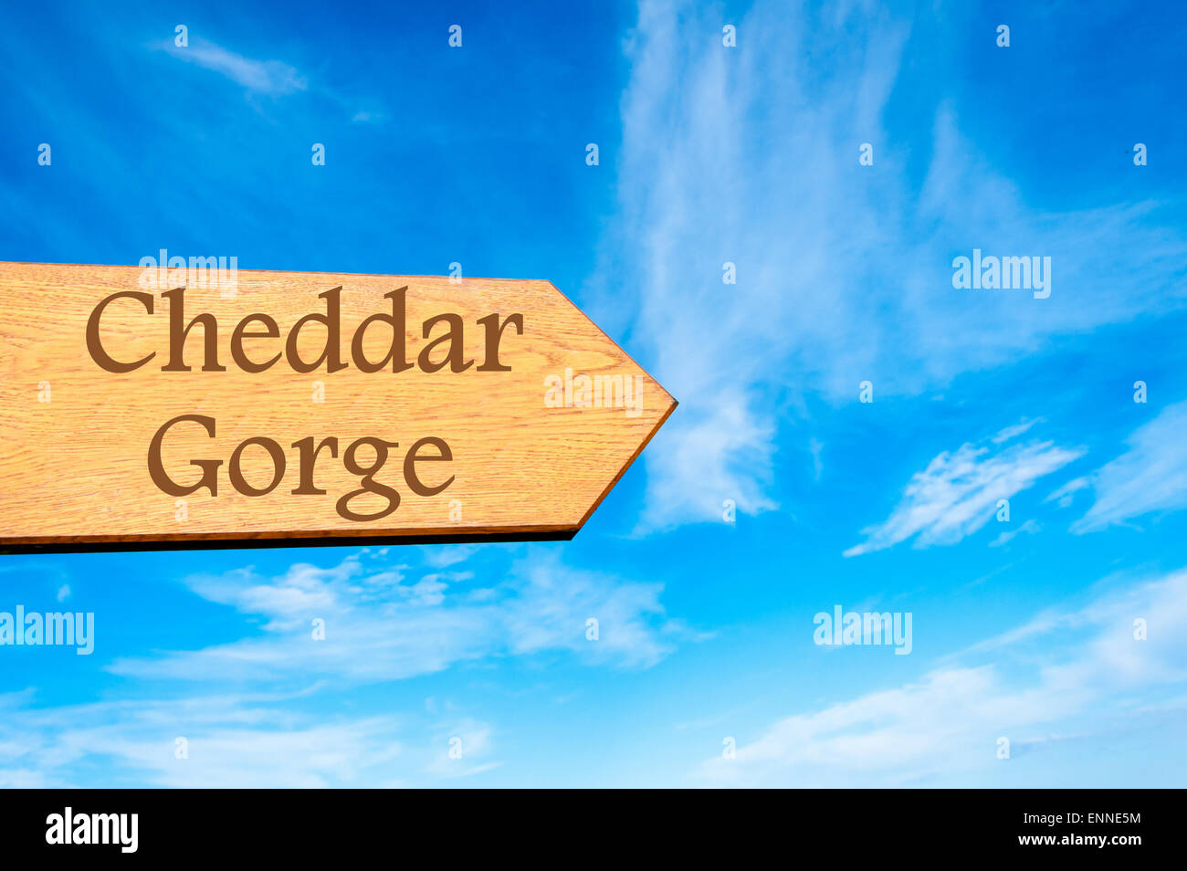 Wooden arrow sign pointing destination CHEDDAR GORGE, ENGLAND against ...
