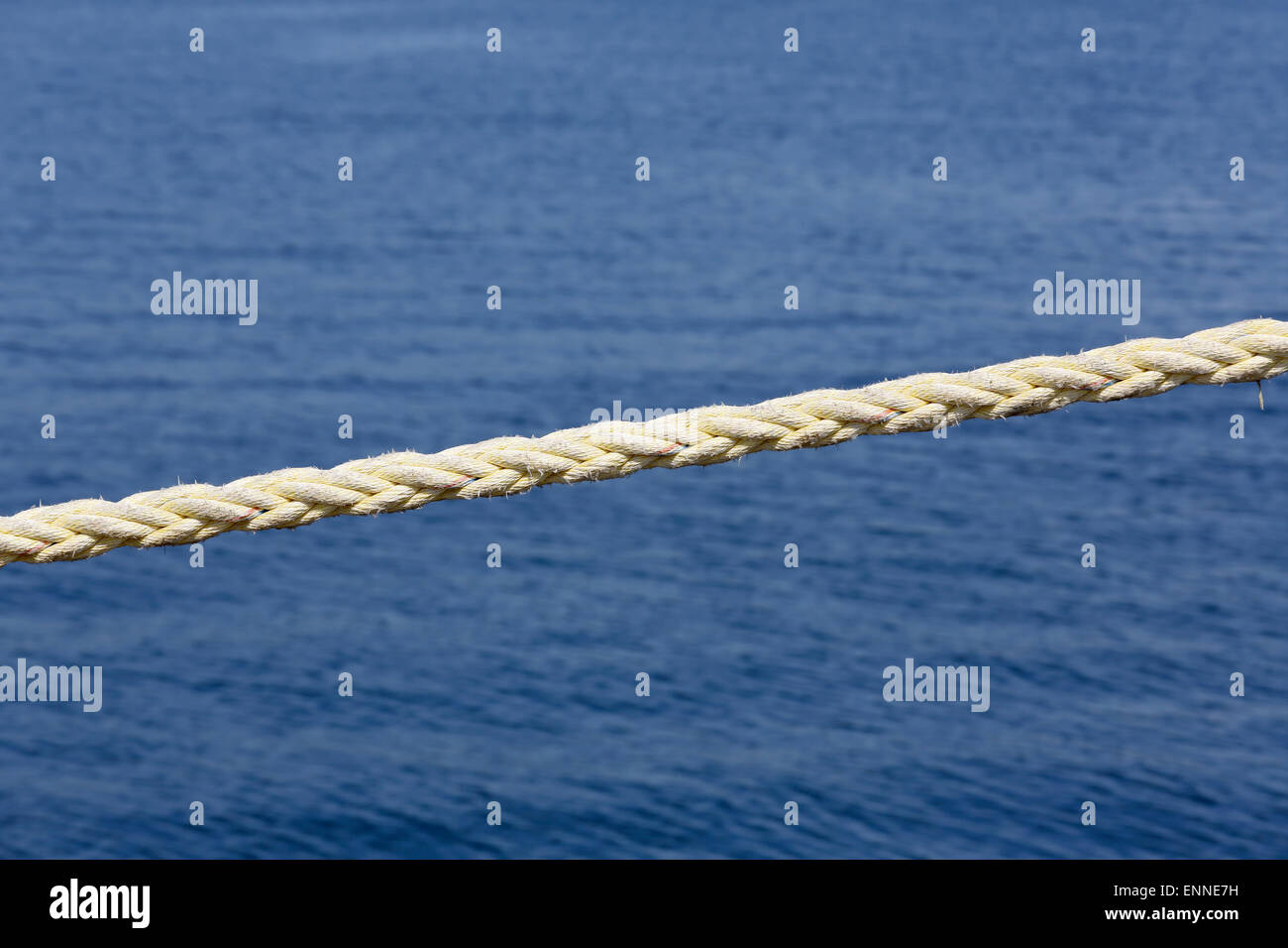 Weathered harbor rope against a blue ocean background Stock Photo - Alamy