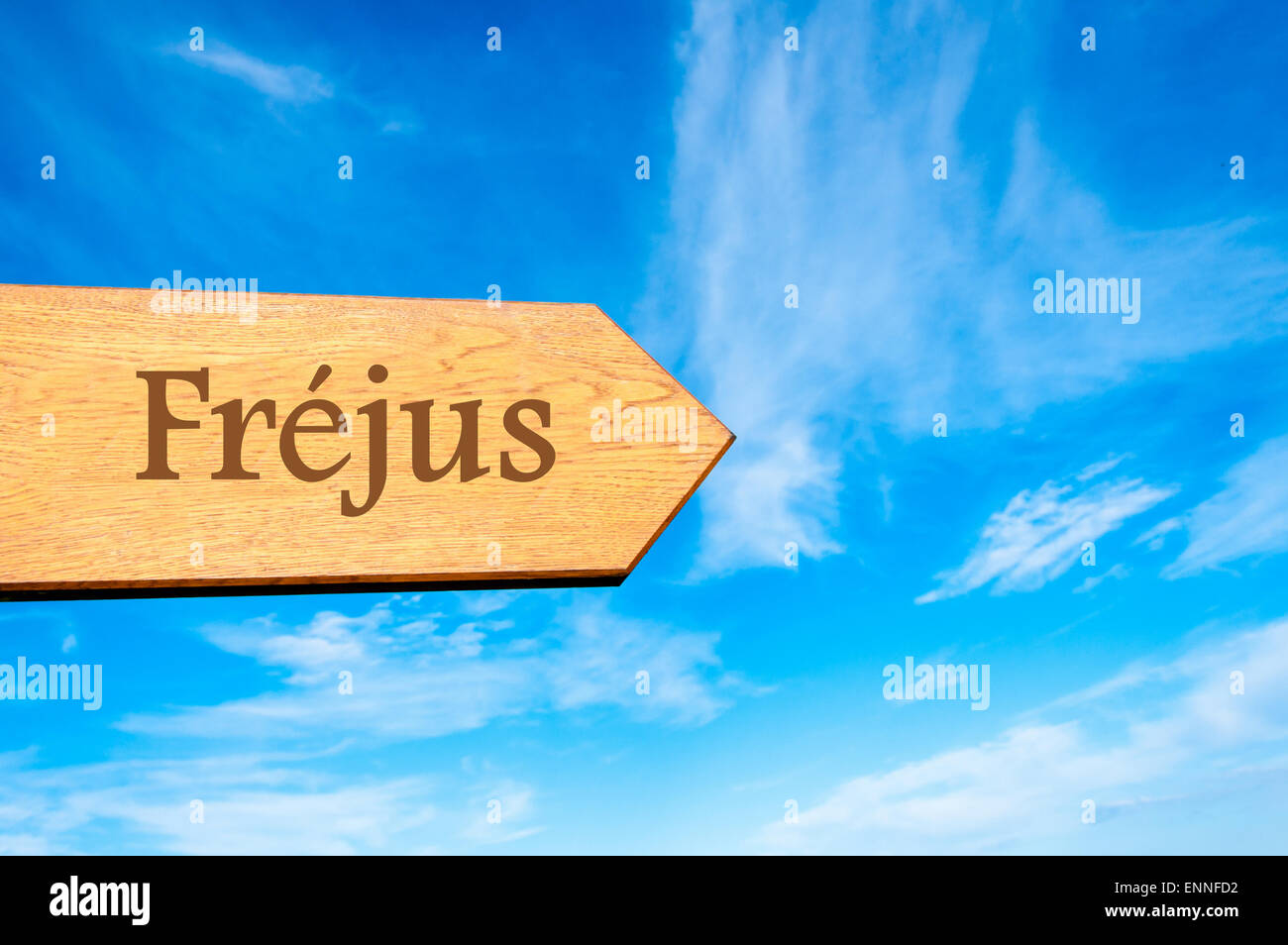 Wooden arrow sign pointing destination Fréjus, FRANCE against clear ...